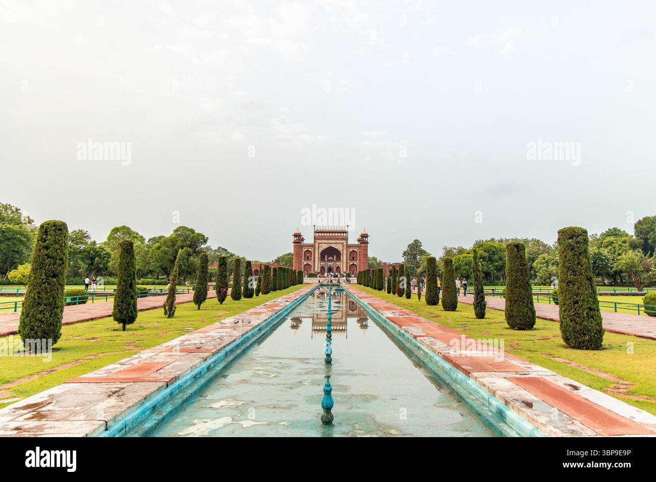 Long turquoise reflecting pool with small fountains leading to the Taj ...