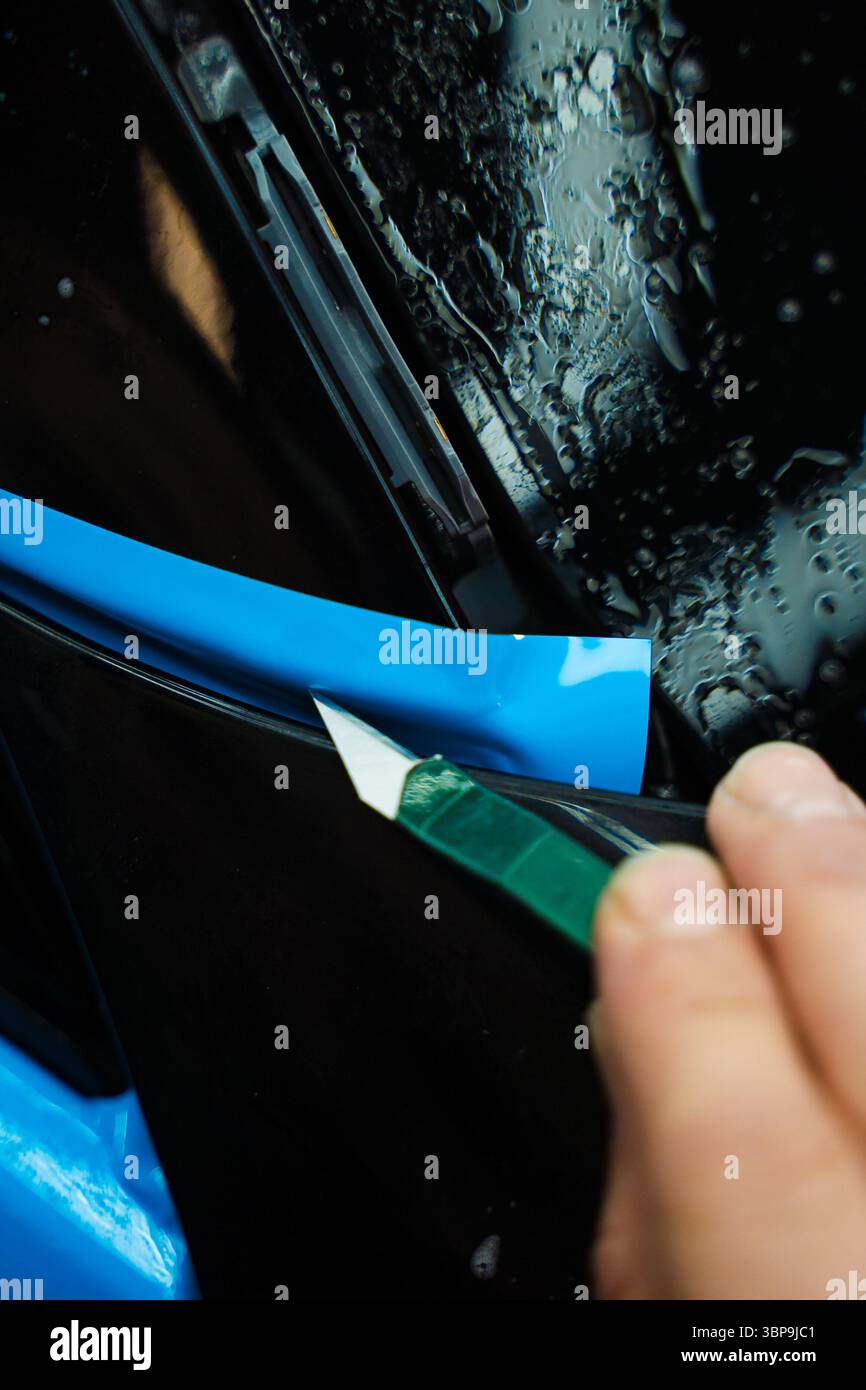 Cutting blue PPF with blade. Cutting blue paint protection film with ...