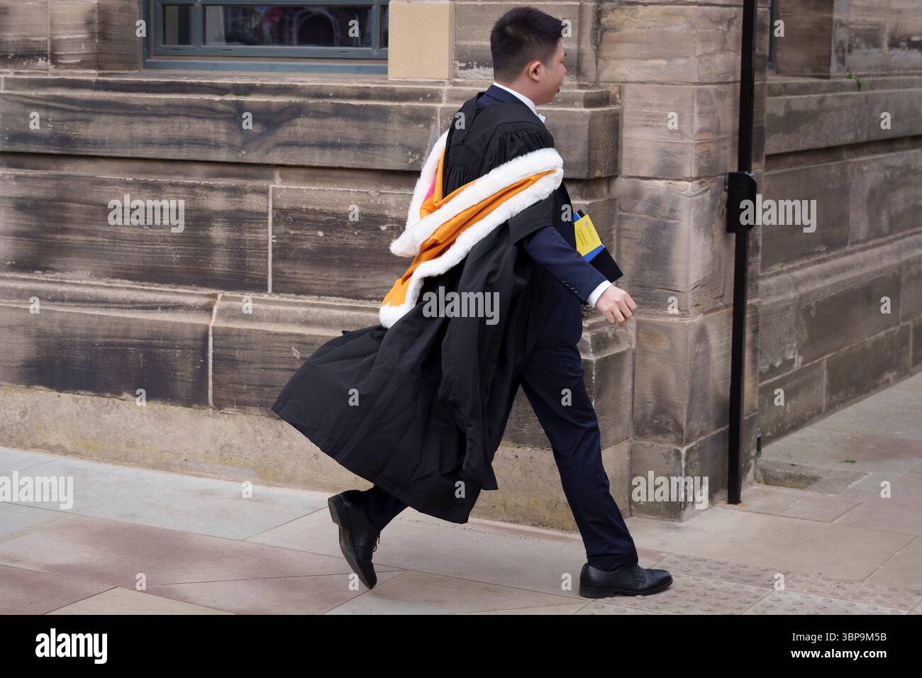 A delayed foreign graduand hurries into his graduation ceremony at the ...