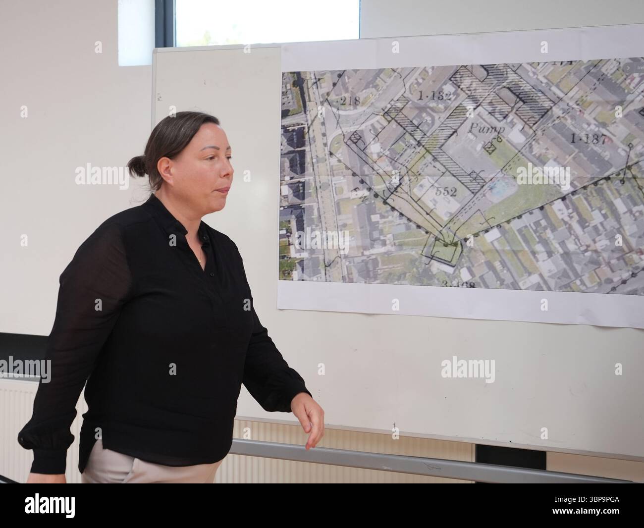 Dr Niamh McCullagh walks past a map of the site, after the media ...