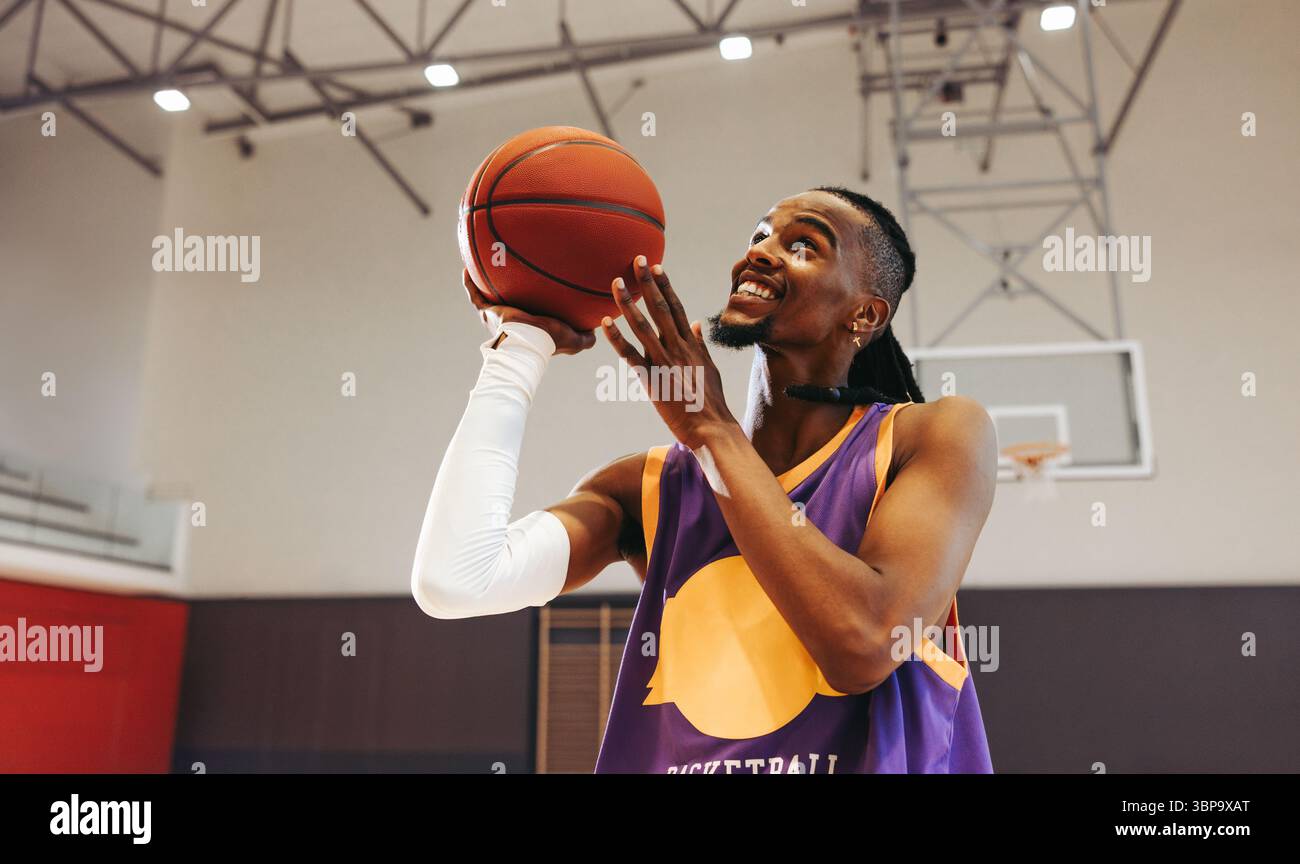 Athlete preparing to shoot a basketball in a well-lit indoor court ...