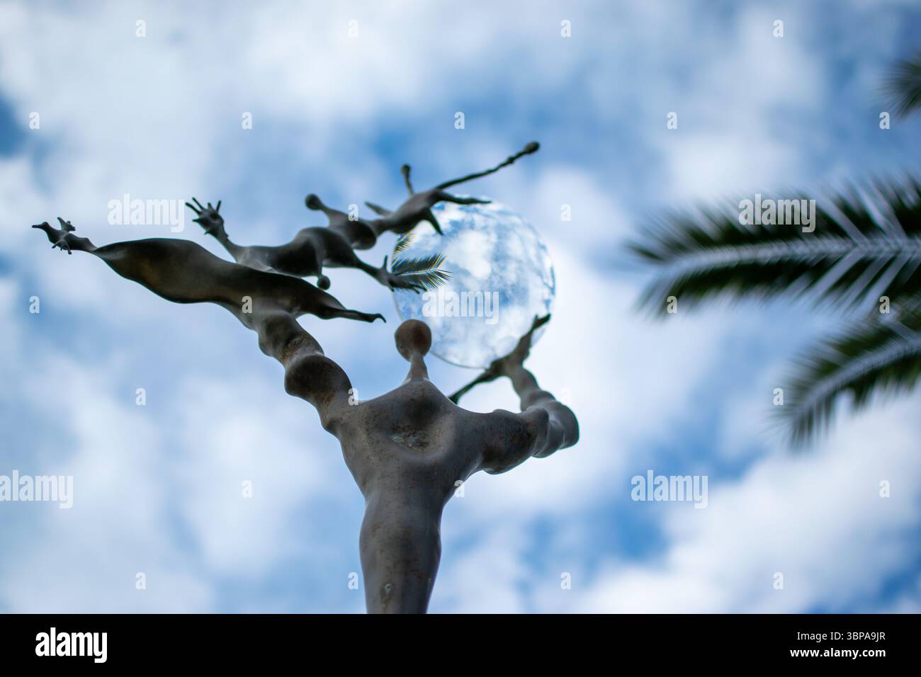 Abstract Human Figures Reaching Toward Globe in Sculptural Composition ...