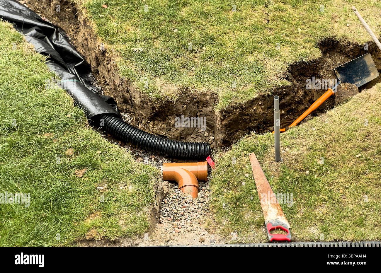Pipe laying & trenching work in progress on a grassy lawn for field ...
