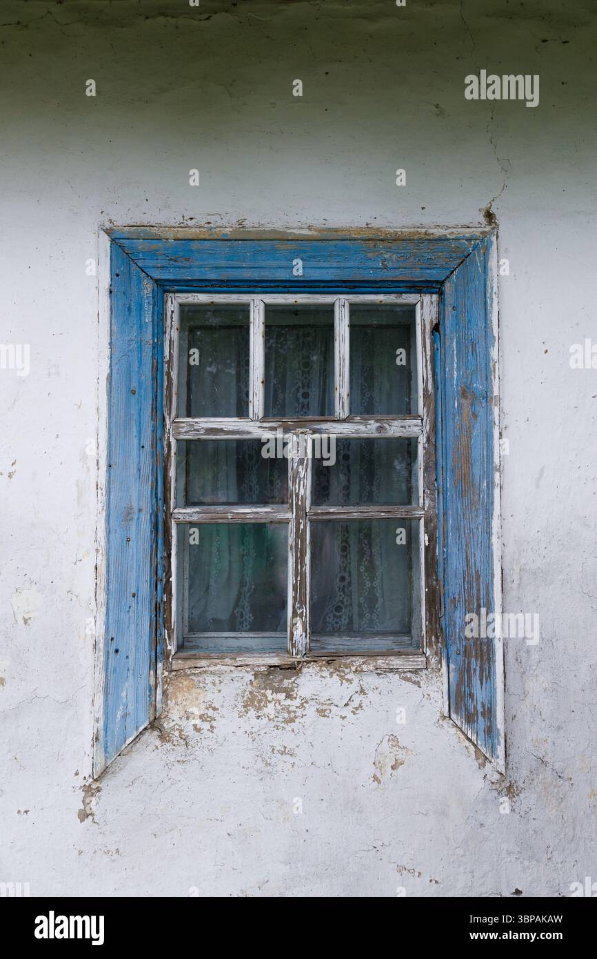 Rustic Window with Blue Frame and Weathered White Wall, Showcasing the ...