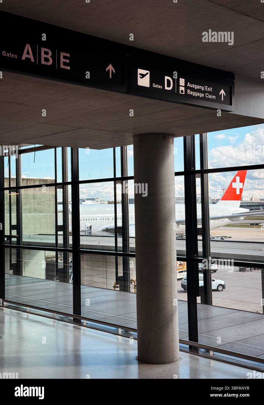 Travelers at Zurich airport see flight information signs while planes ...