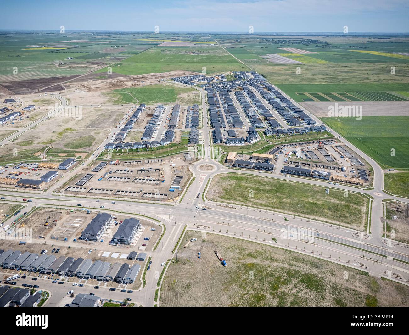 Large, empty lot with a few houses in the distance. The houses are ...