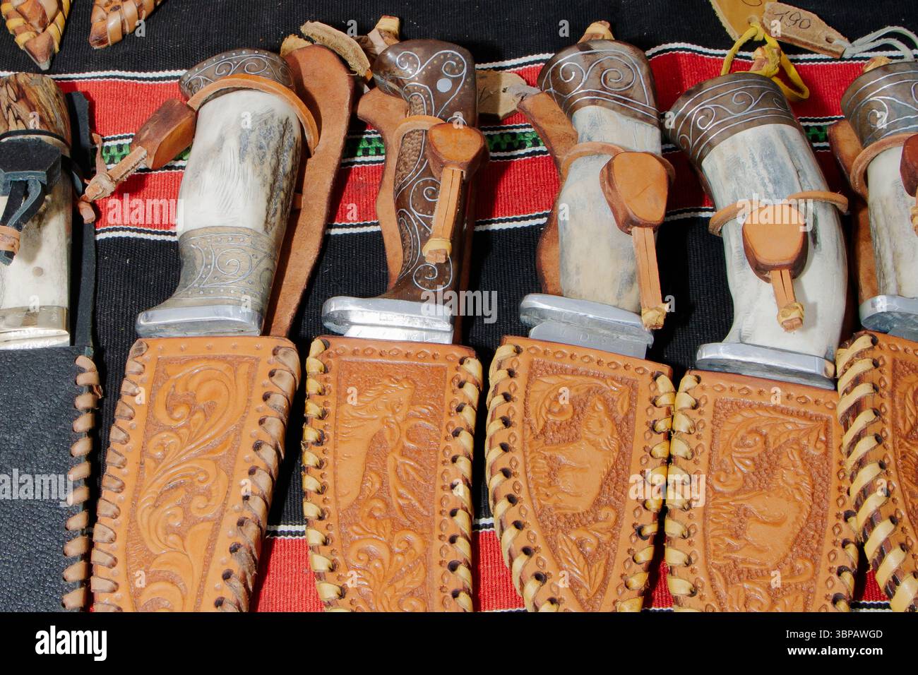 Craftsmanship is showcased with beautifully carved knives lined up ...