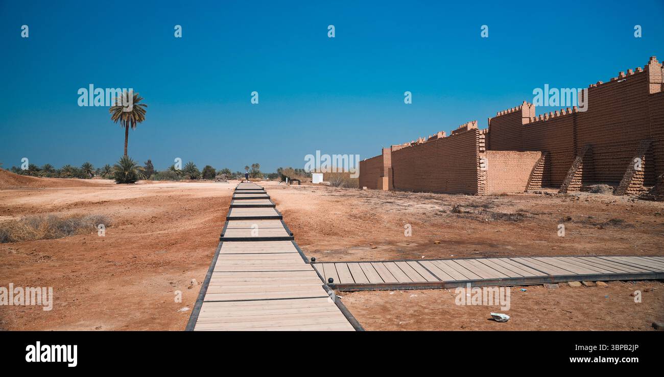 Visitors explore the ancient site of Babylon, walking along a wooden ...