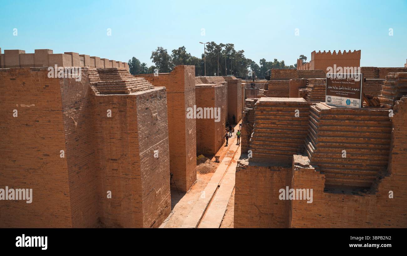Visitors explore the ancient ruins of Babylon, Iraq, observing the well ...