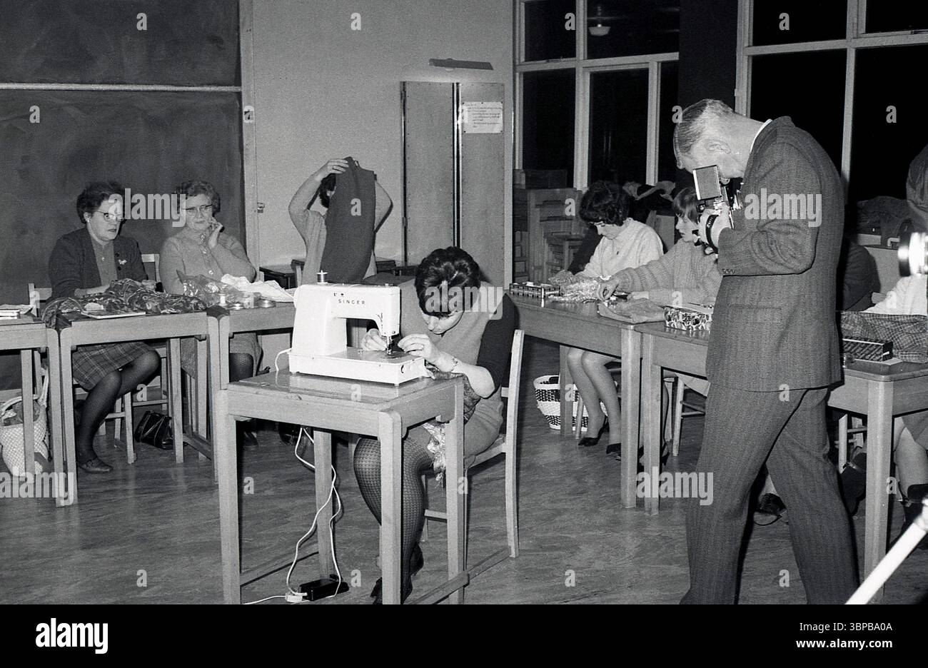 1960s, historical, ladies in an evening sewing class, one in the middle ...