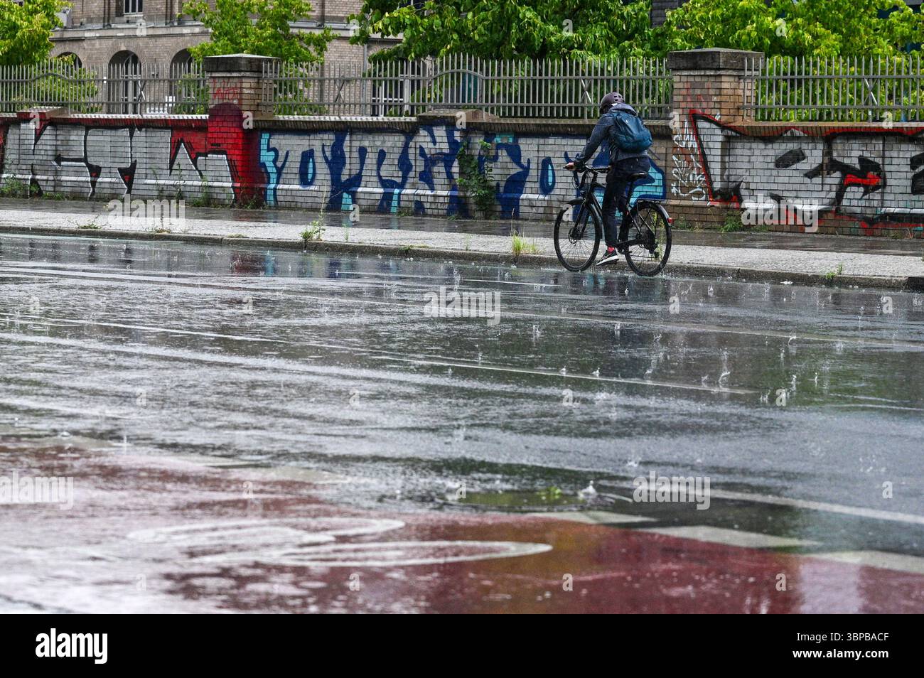 07 July 2025, Berlin: Heavy rain showers fall in Stralauer Allee. After ...