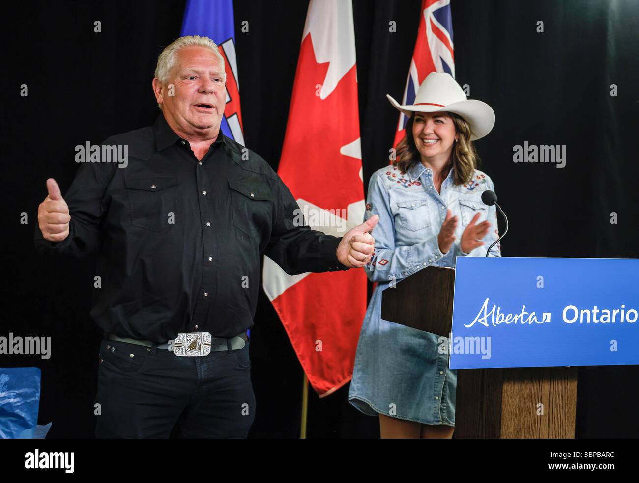 Ontario Premier Doug Ford, left, models a new belt buckle presented to ...
