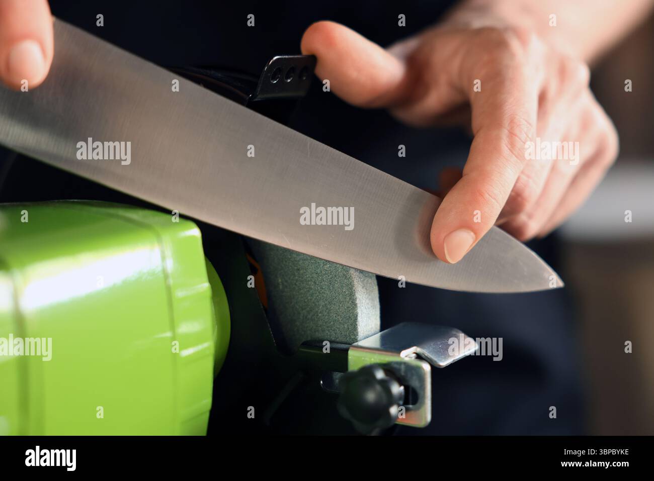 Man sharpening knife with bench grinder indoors, closeup Stock Photo ...