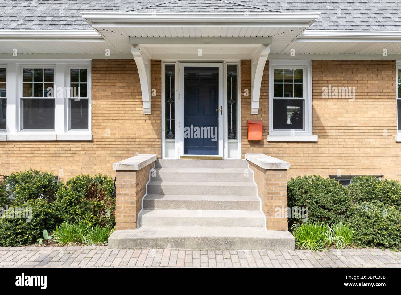 A front door detail with a white overhang on a brick home, brick ...