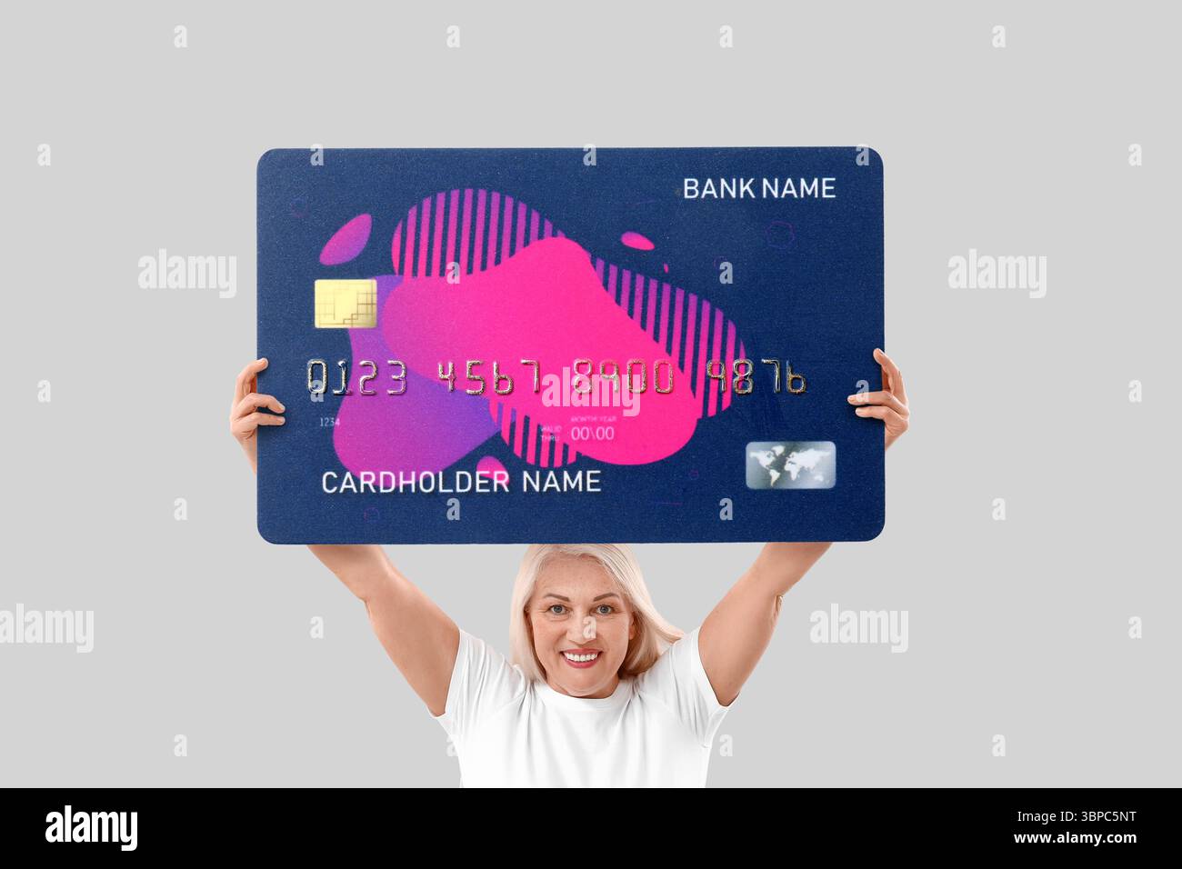 Mature woman with big credit card on grey background Stock Photo - Alamy