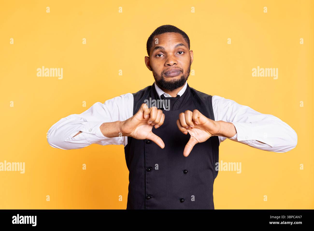 Restaurant staff with apron and uniform giving a thumbs down sign ...