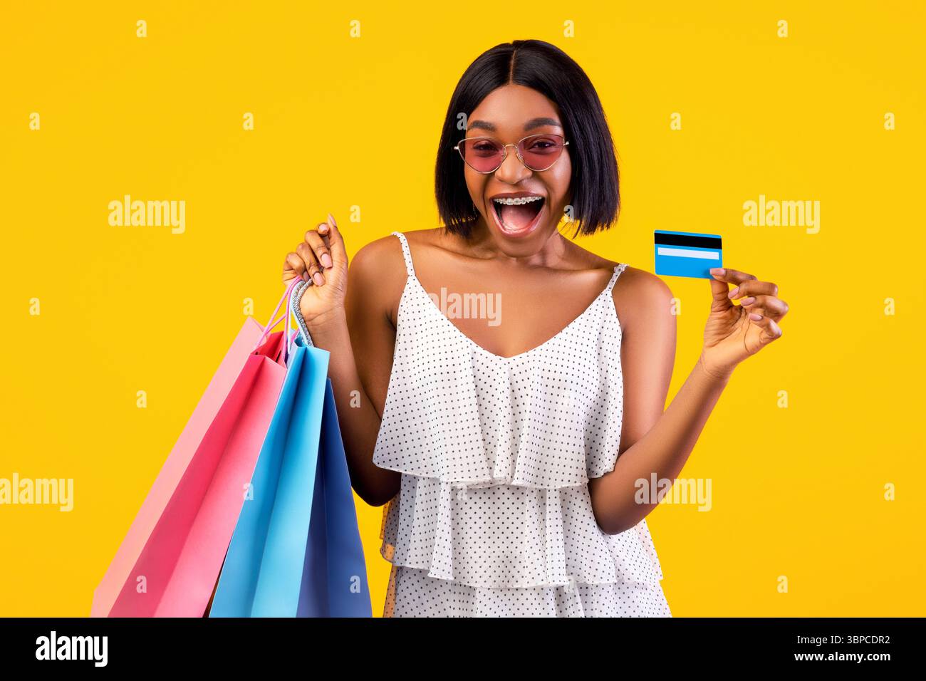 Summertime sales. Excited black woman with shopping bags showing credit ...