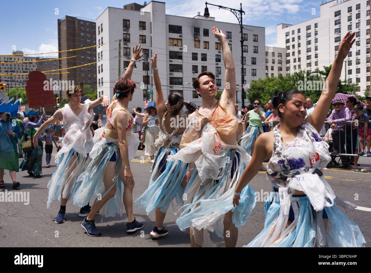 A street parade features several individuals in costumes crafted from ...