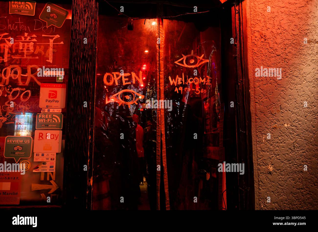 Moody entrance to a bar in a narrow Tokyo food street, glowing with ...