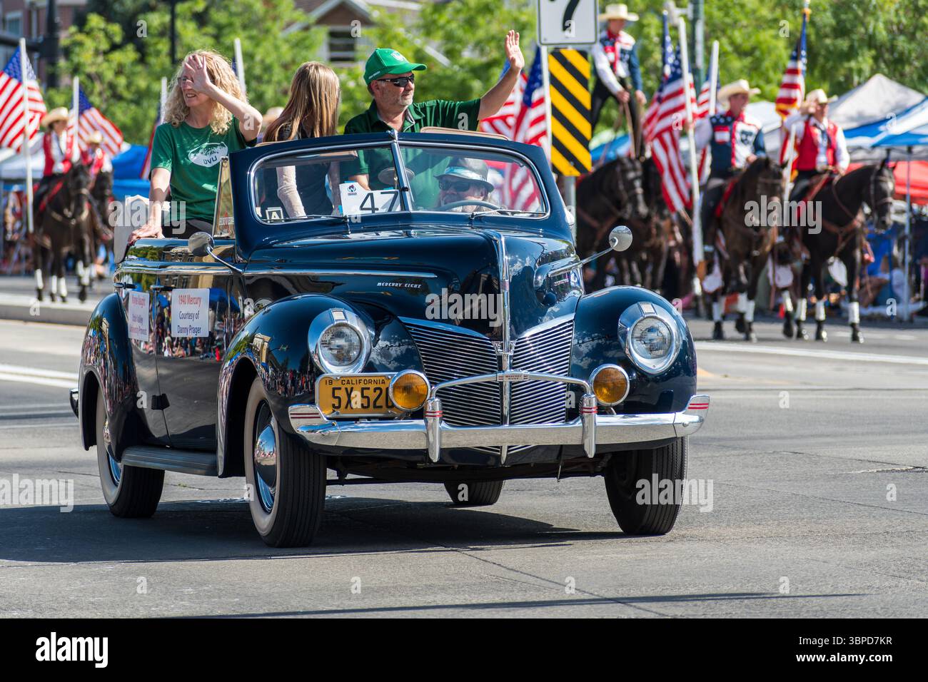 Provo, Utah – July 4, 2025: People ride and wave from a vintage ...