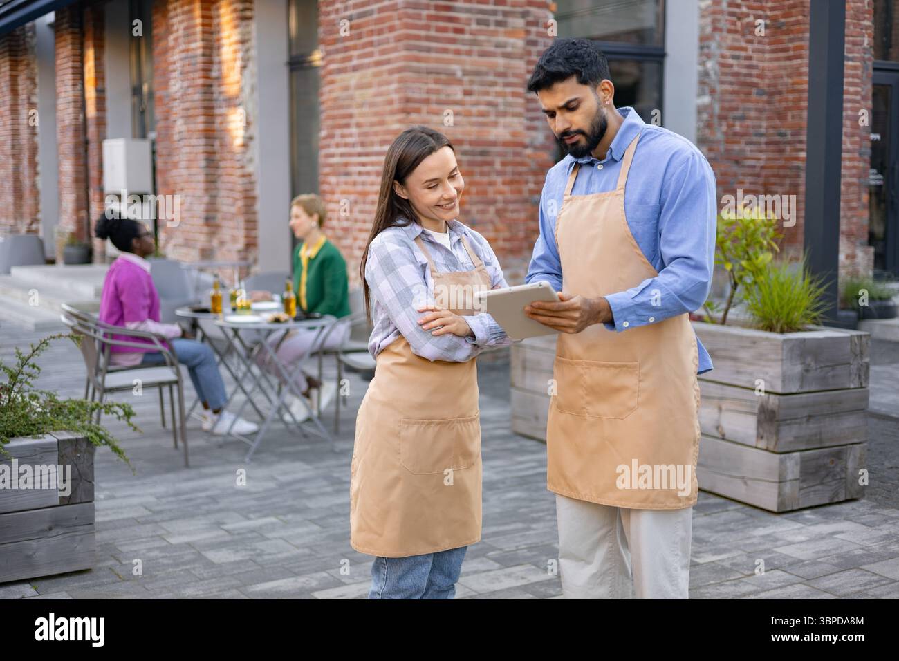 Restaurant Staff Using Tablet Outside Stock Photo - Alamy