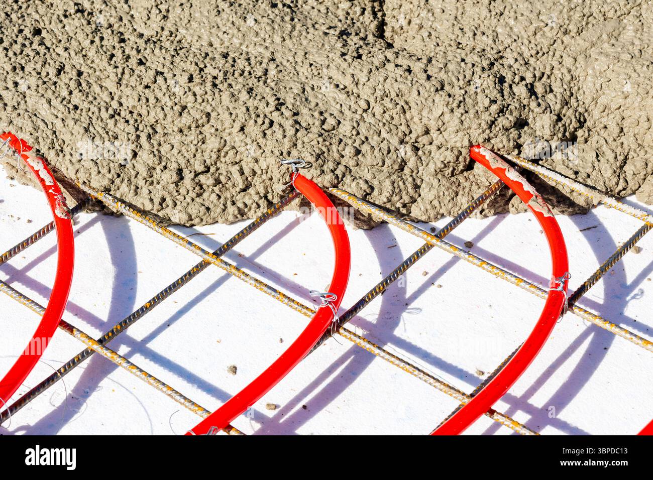 Concrete pouring over underfloor heating pipes and mesh Stock Photo - Alamy
