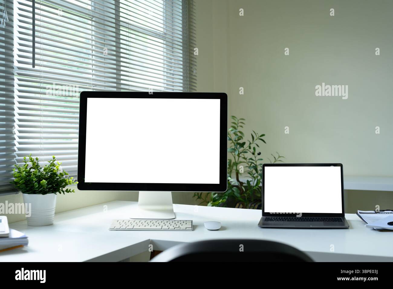 Modern home office with desktop monitor and laptop, both displaying ...