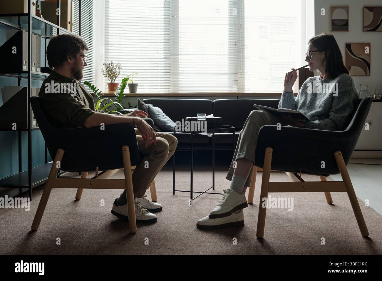 Young Woman Conducting Therapy Session with Young Man Stock Photo - Alamy