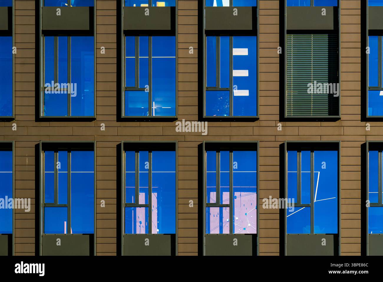 Symmetrical office building facade with repetitive windows and warm ...