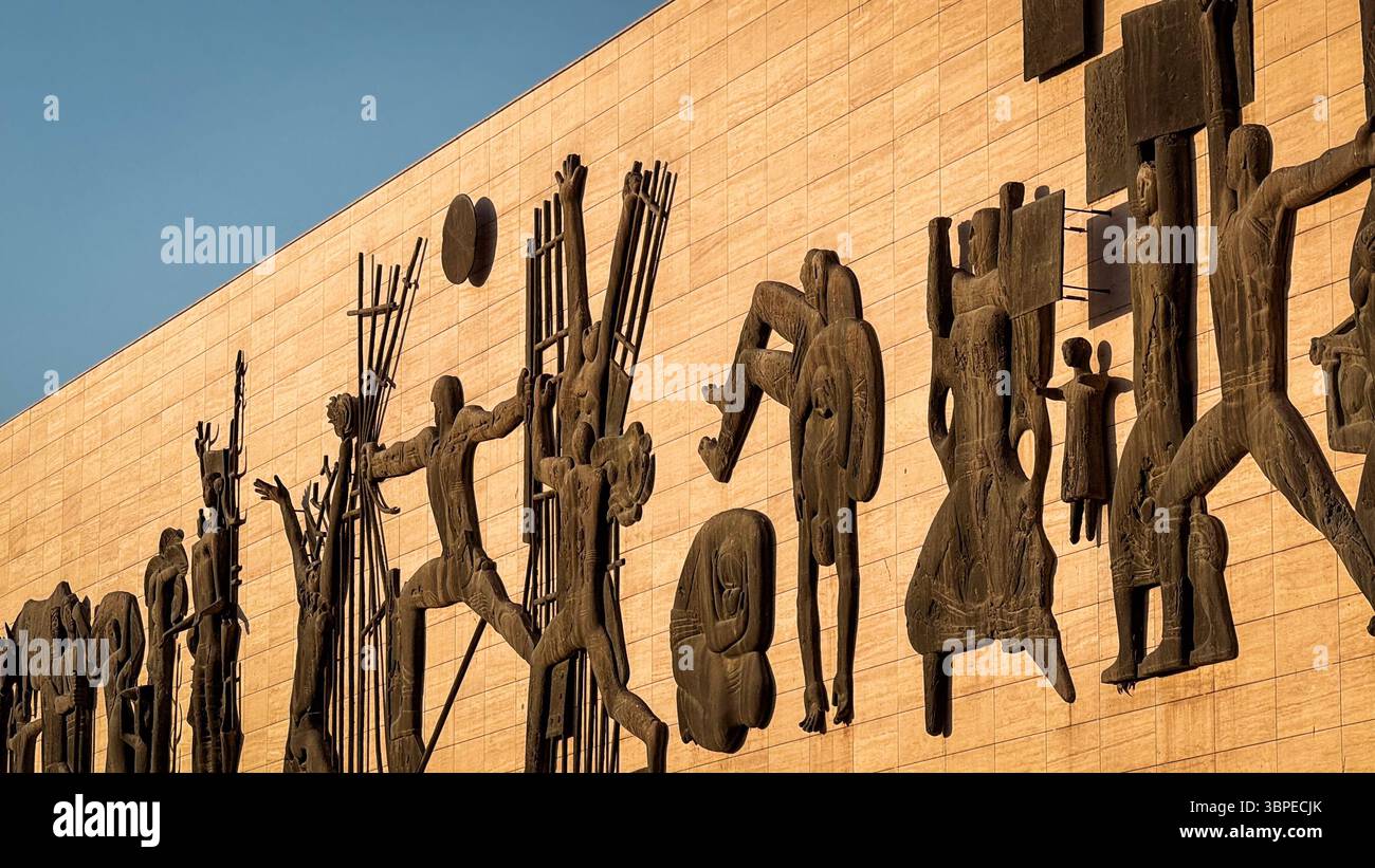 Bronze sculptures depict various human figures and activities on the ...