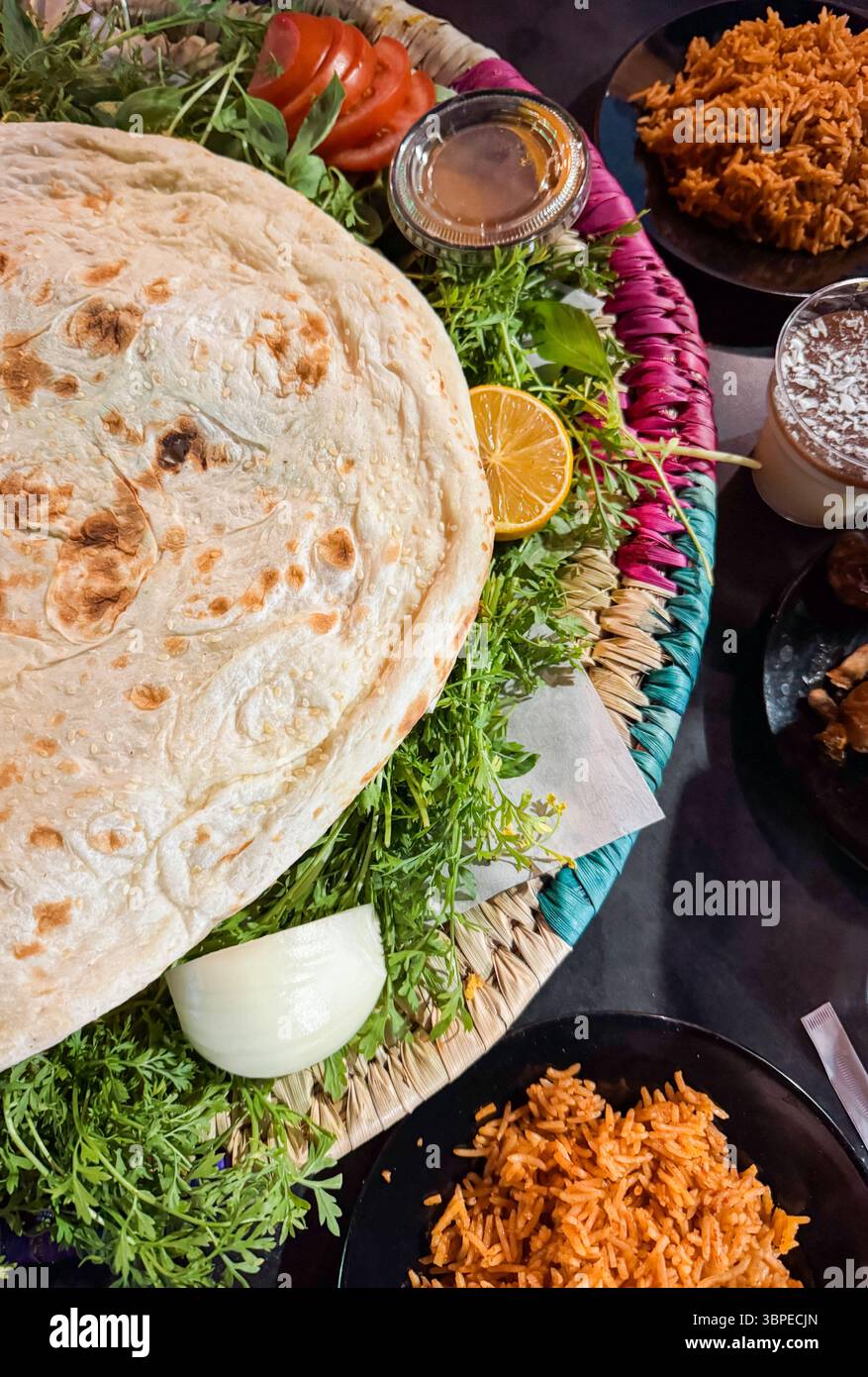 Savoring authentic Iraqi food with large flatbread surrounded by fresh ...