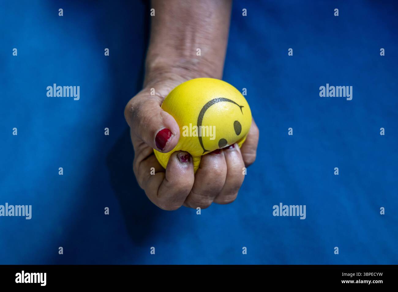 disabled person pressing smiley ball in hand for strengthen the muscles ...