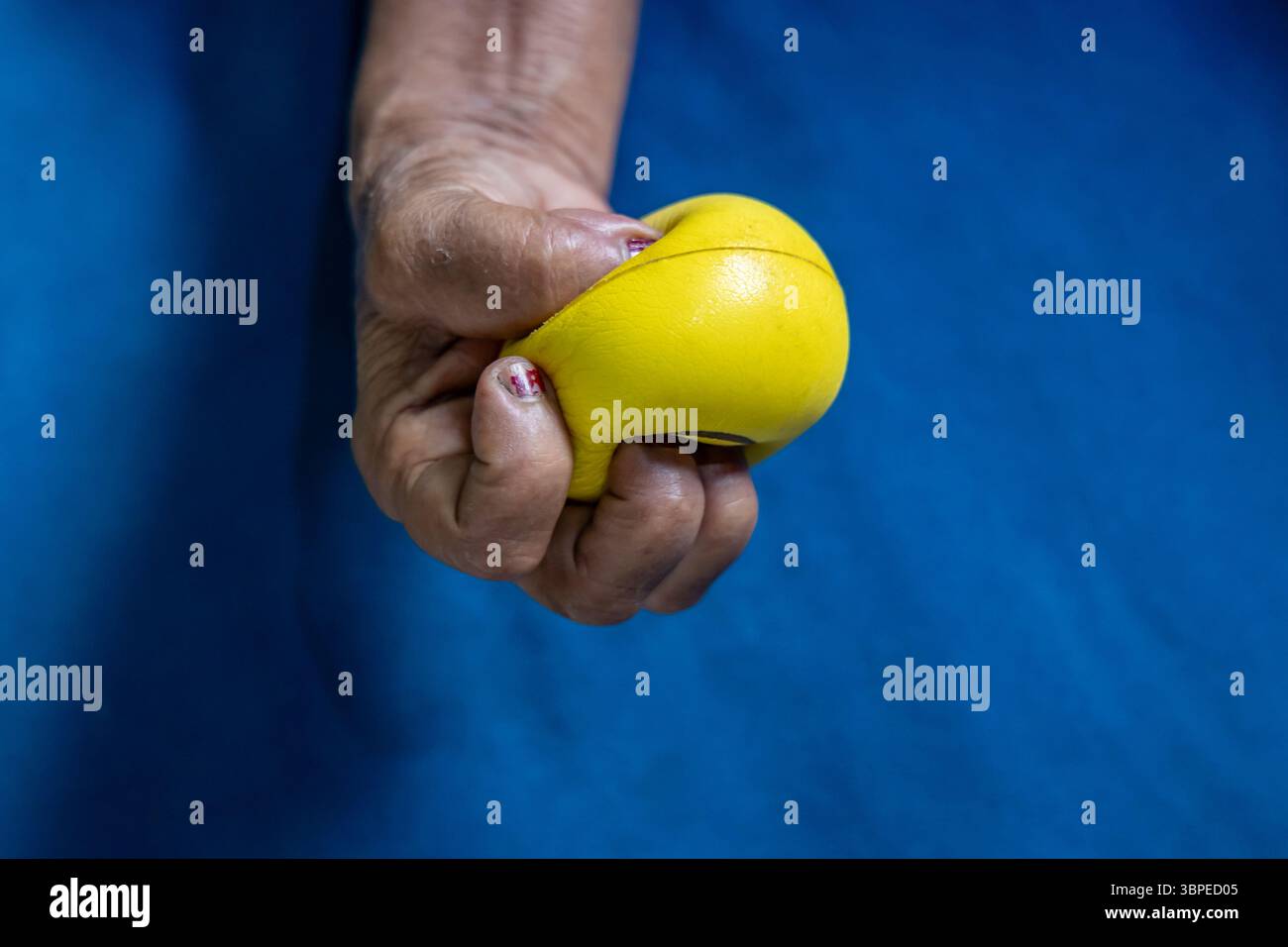 muscle strengthening exercise with stress ball indoors Stock Photo - Alamy
