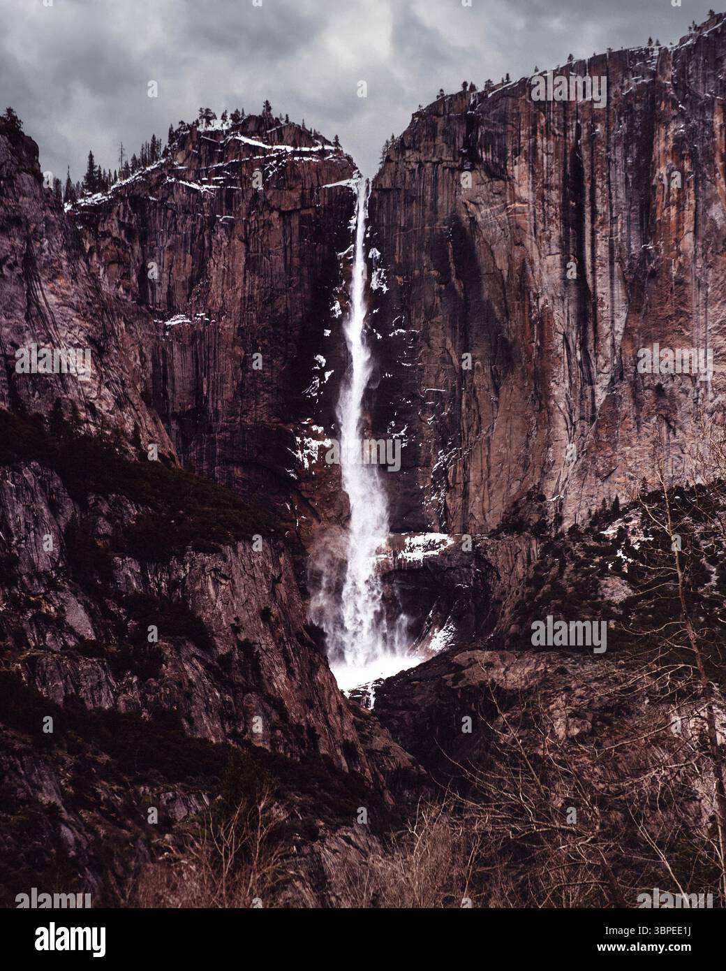 View of a dramatic cascade of water plunges from the towering cliff ...