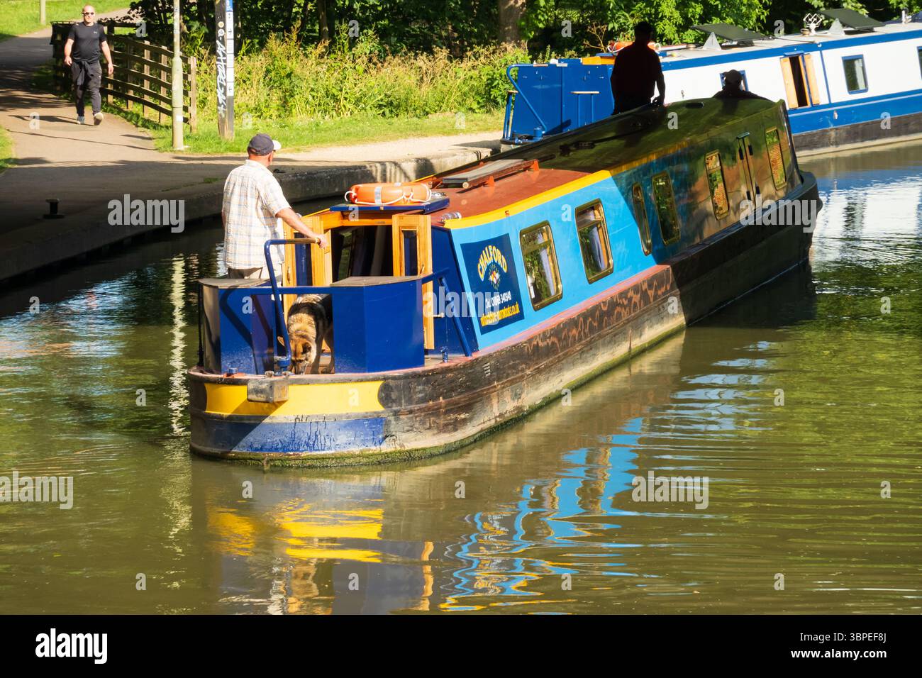 Narrow-boat canal barge with crew of two and dog on the Oxford Canal at ...