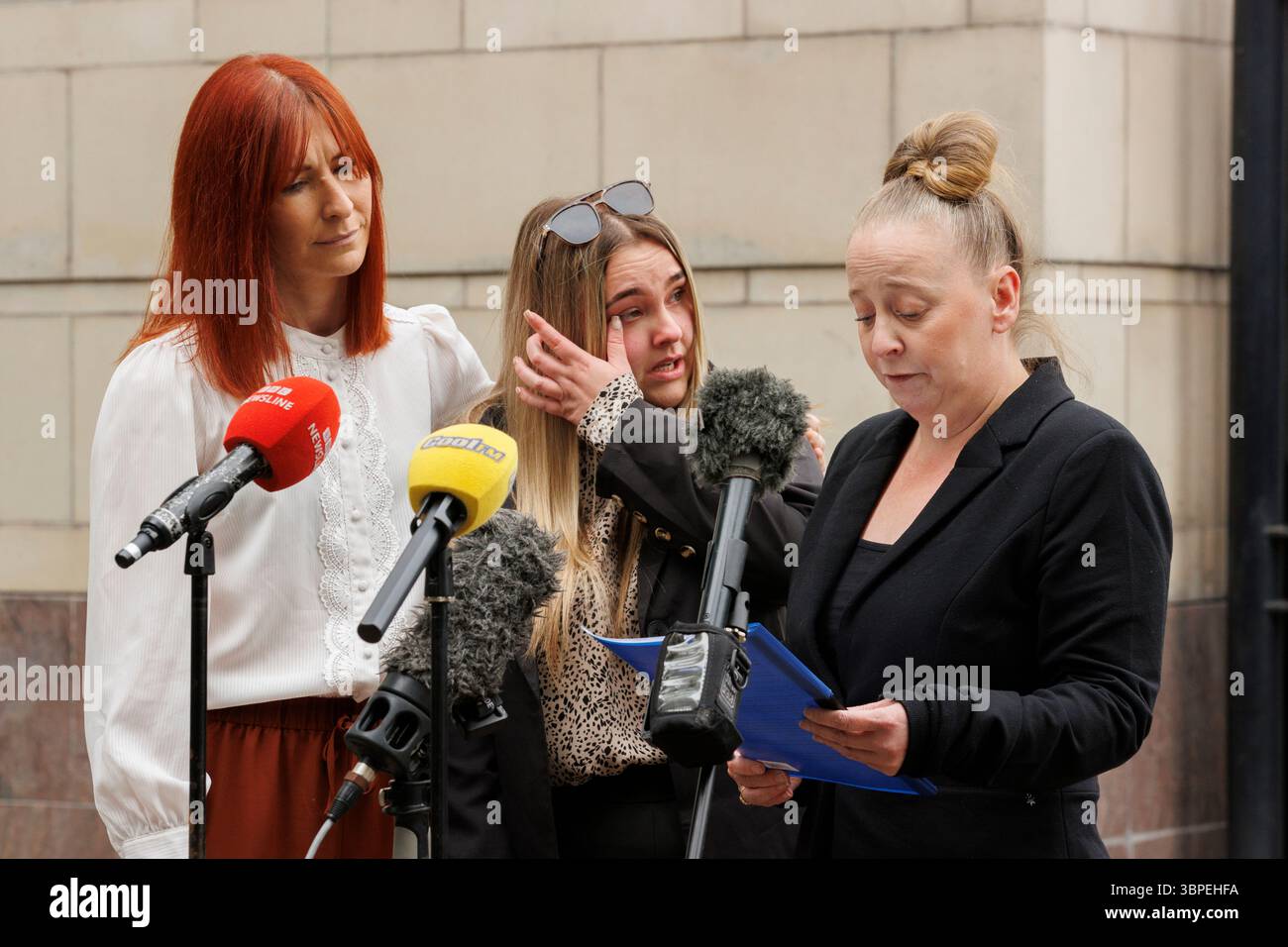 Paul Rowlands' sister Cheryl Burns (right) reads out a family statement ...