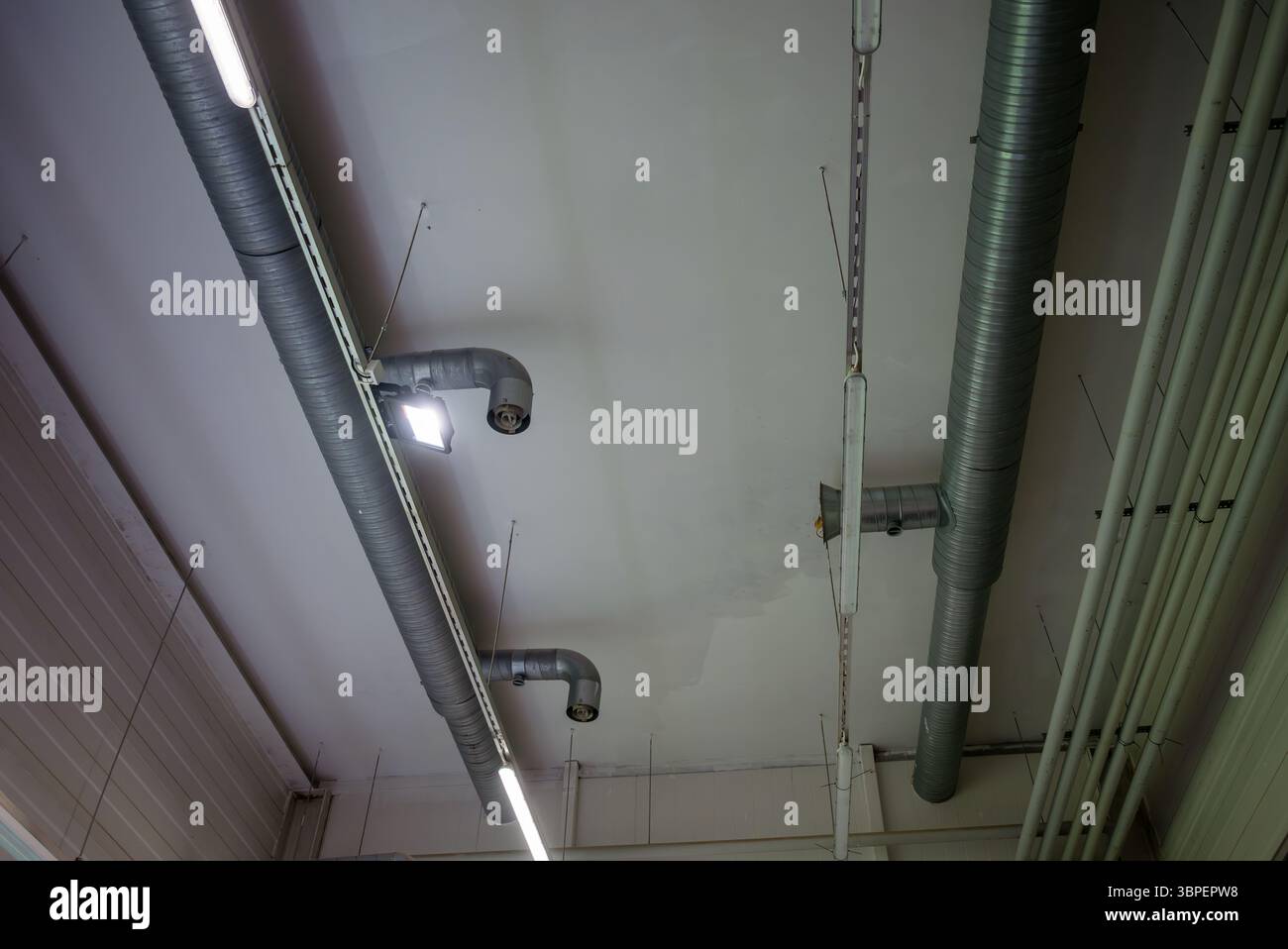 Industrial ceiling with ventilation ducts and fluorescent lights inside ...