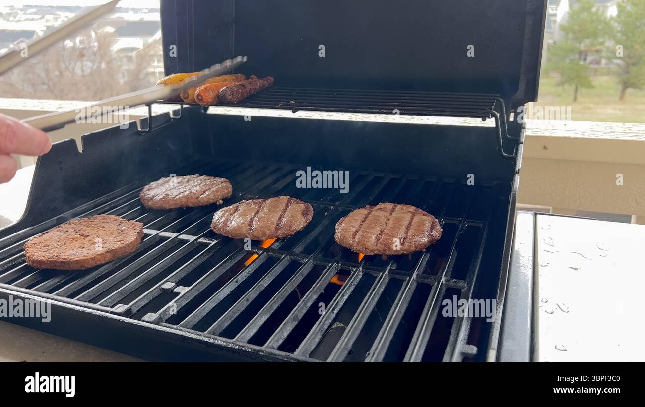 Grilling Burgers and Sausages on Open Gas Grill in Backyard Stock Photo ...
