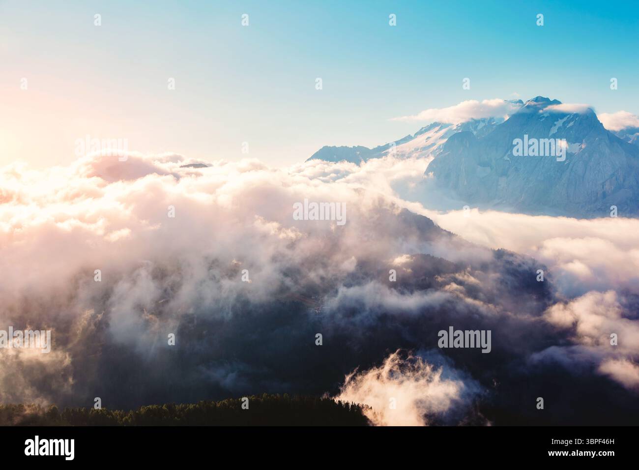 Creamy fog covered the famous glacier Marmolada in morning light ...