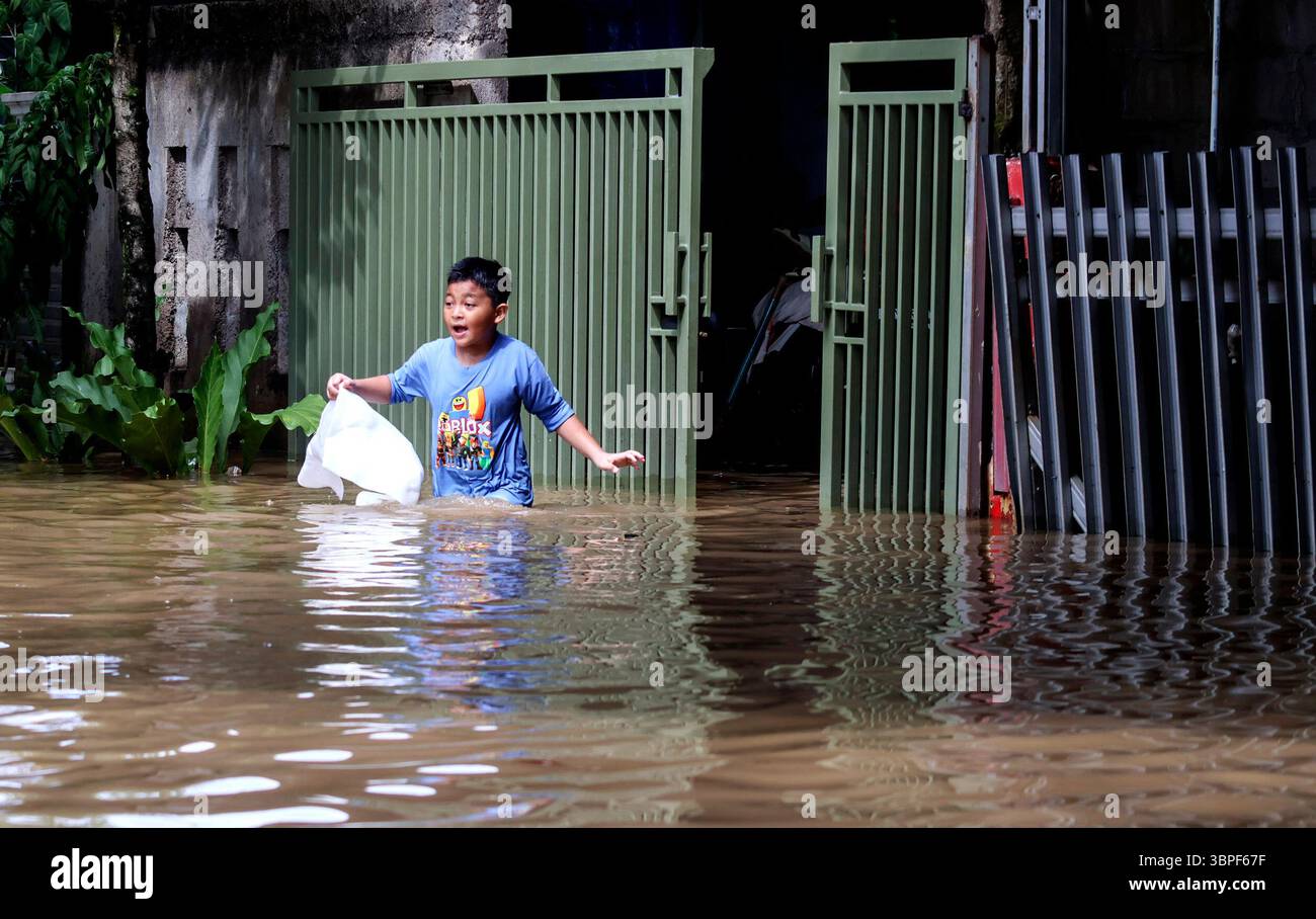 (250708) -- BOGOR, July 8, 2025 (Xinhua) -- A boy walks through flood ...