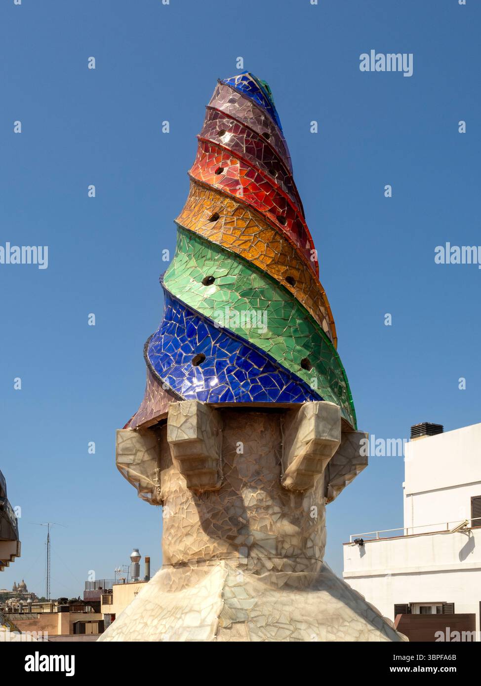 A sculptural chimney with a swirling rainbow-coloured 'trencadís ...