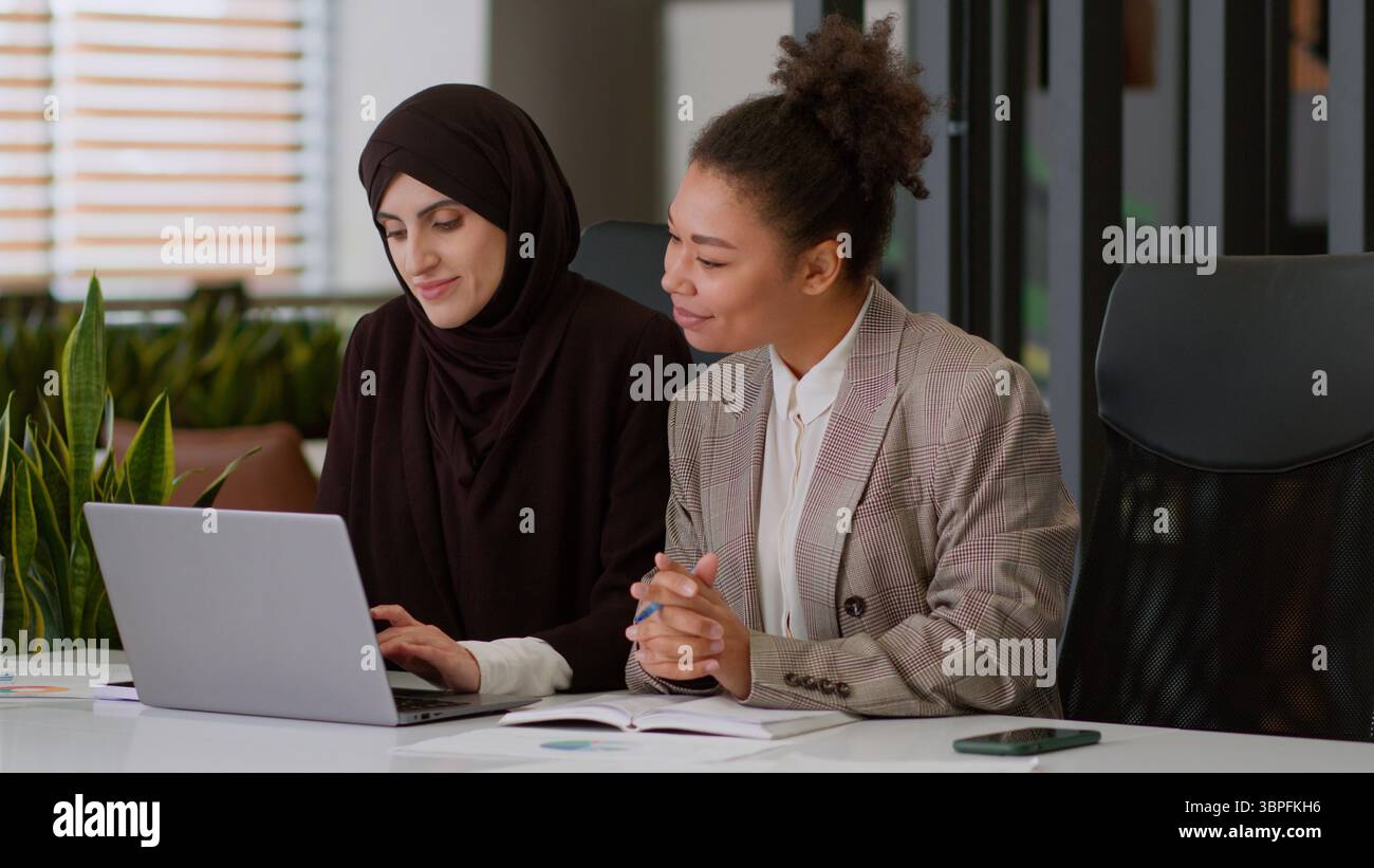 Two multiracial businesswomen female girls ethnic happy colleagues ...