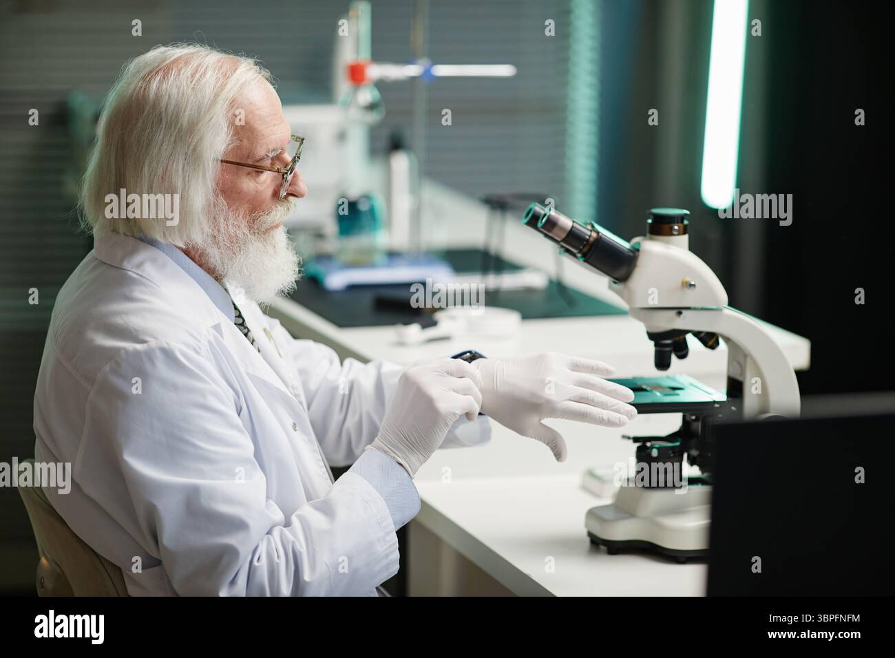 Senior Caucasian man with long hair and beard wearing lab coat and ...