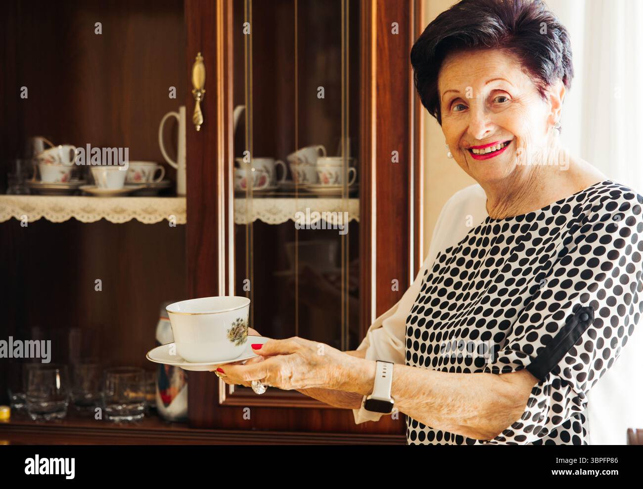 Smiling senior woman showing vintage teacup in her living room Stock ...