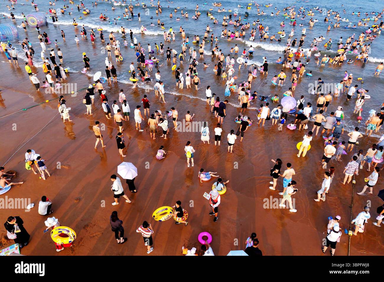 People seek coolness on a beach in the summer heat in Qingdao in east China's Shandong province ...