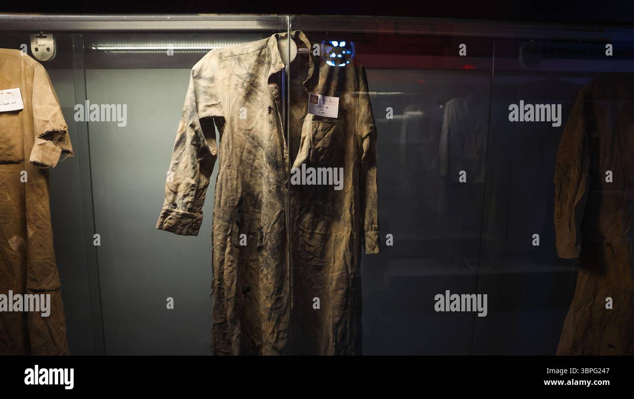 Visitors explore a display showcasing worn clothing items that reflect ...
