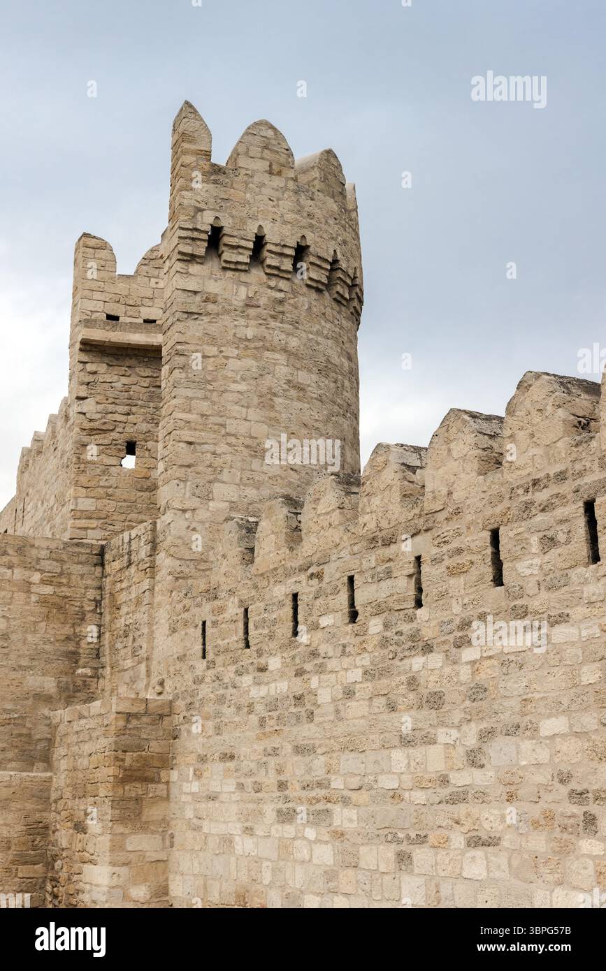 Ancient stone fortress walls featuring a textured round tower under a ...