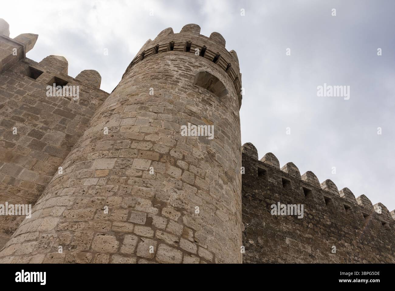Ancient stone fortress featuring round tower under cloudy sky ...