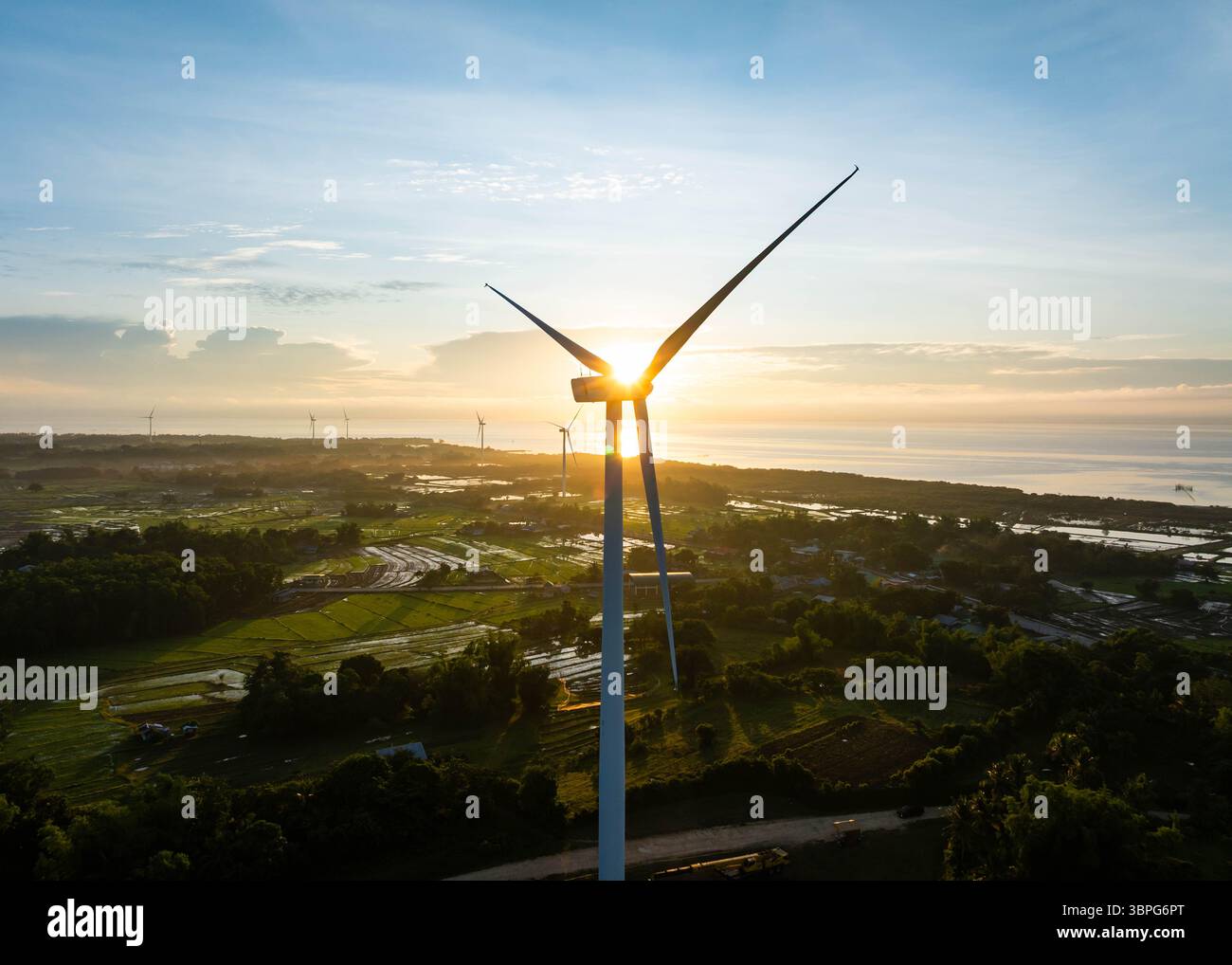 Aerial view of wind turbines standing tall against the vibrant sunset ...
