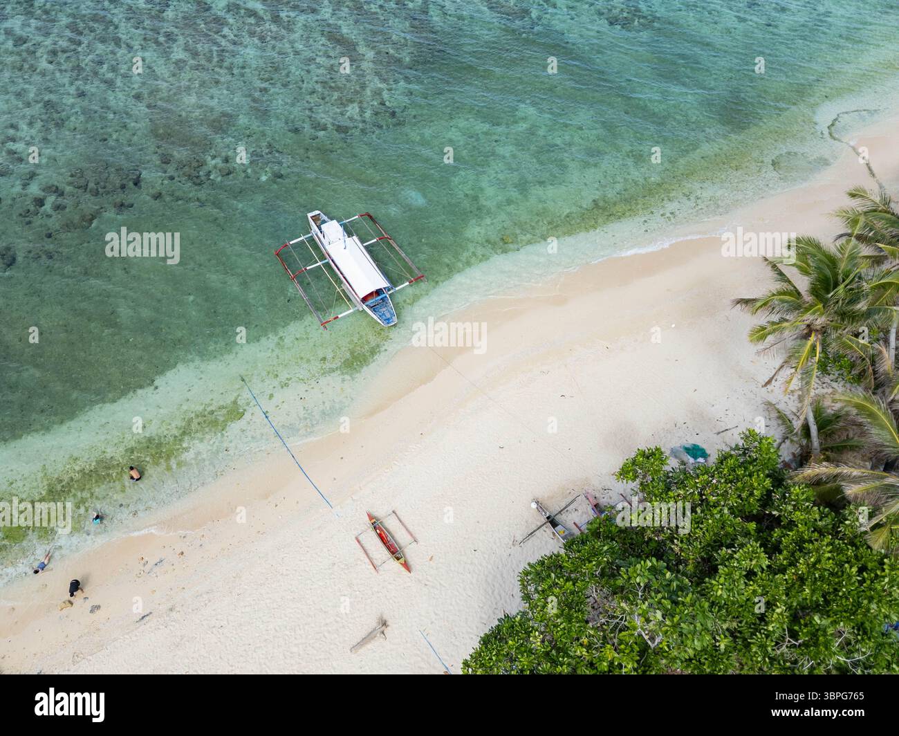 Aerial view of a traditional outrigger boat resting on the pristine ...